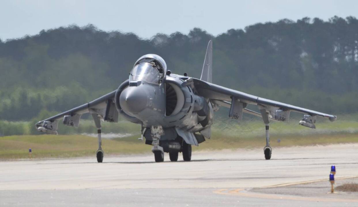 A Marine Corps AV-8B Harrier jump jet flies backwards and sideways at ...