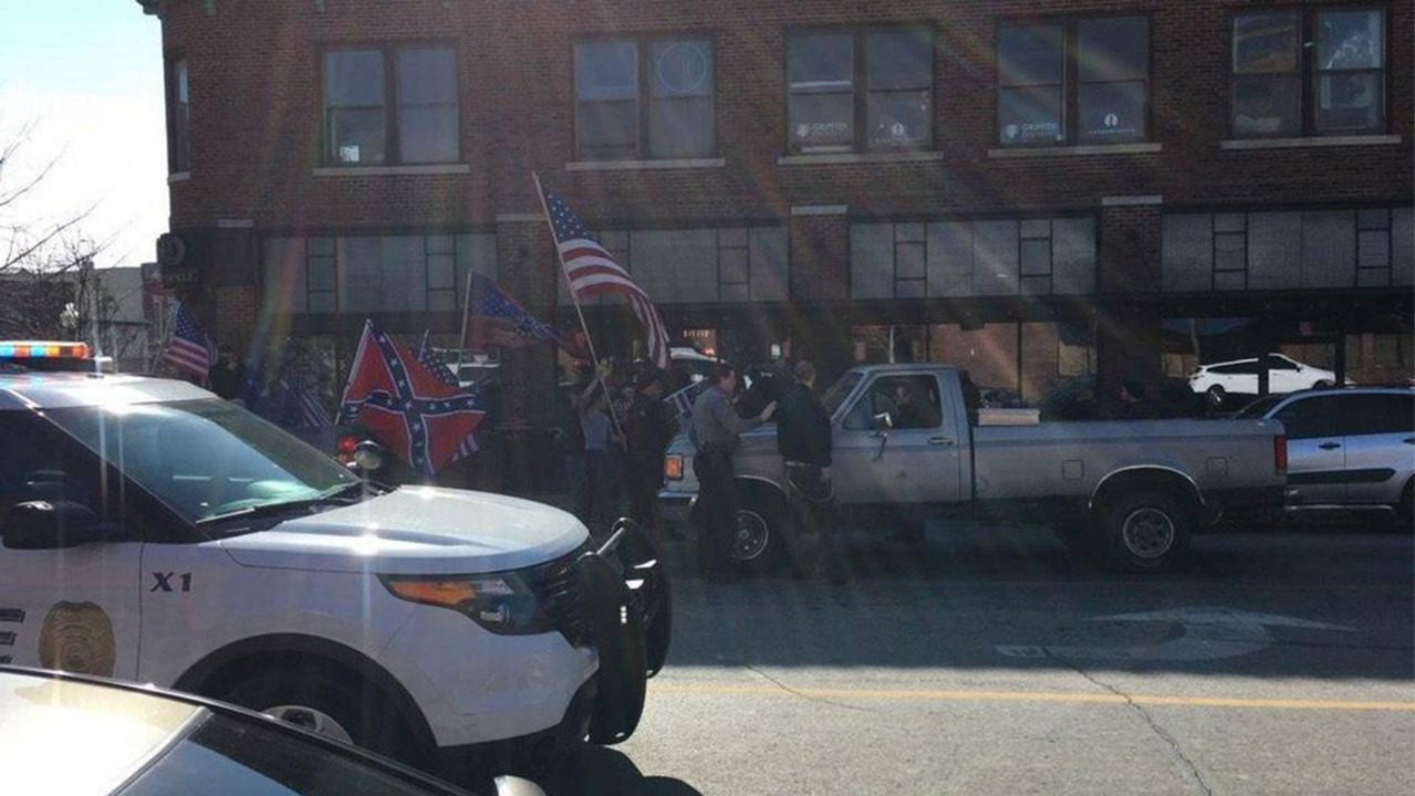 Nearly 25 demonstrators carry US and Confederate flags down Mass Street ...